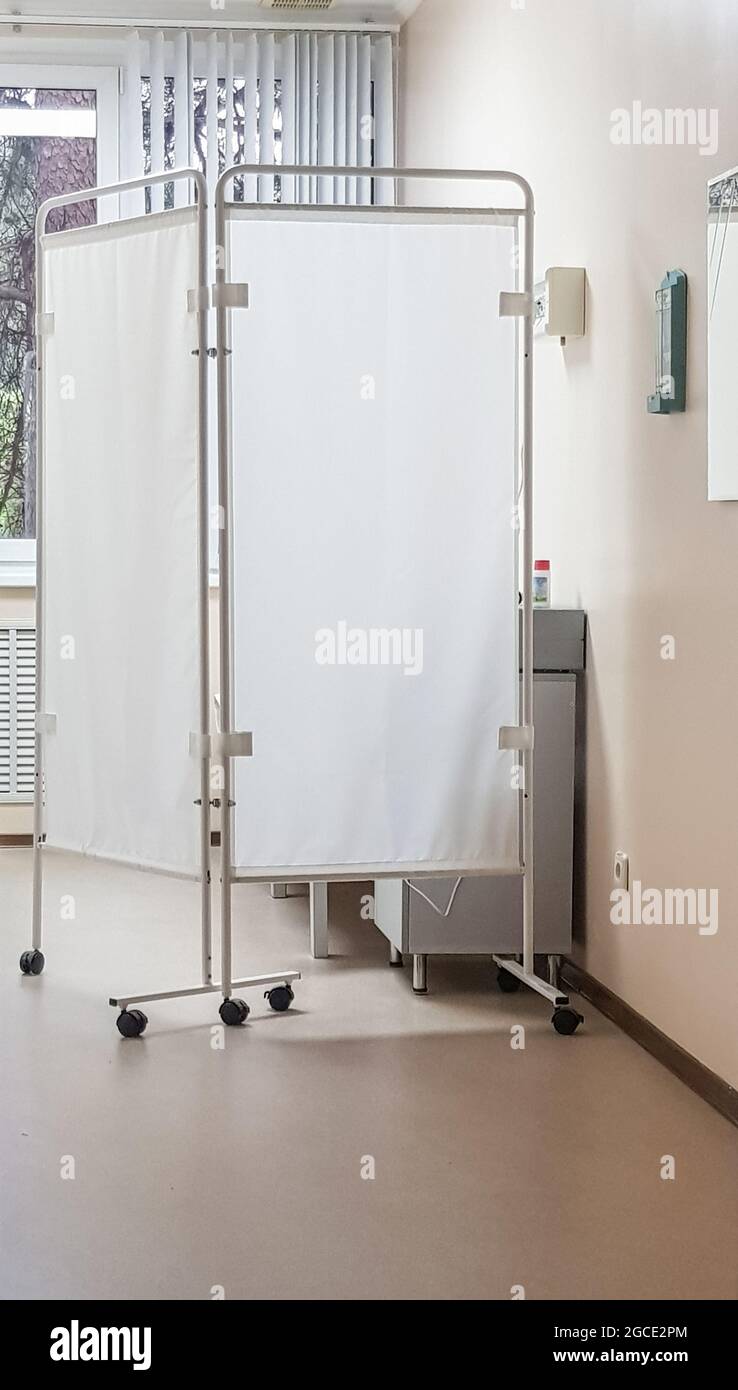 Interior of a bright doctor's office with a folding screen, vertical ...