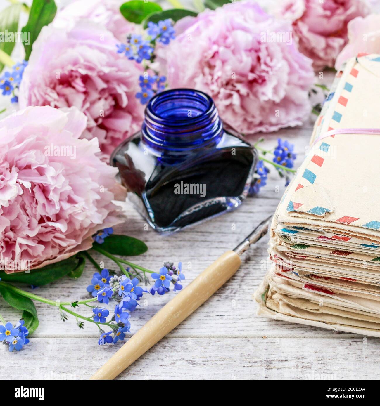Stack of vintage love letters and pink peonies in the background. Retro ...