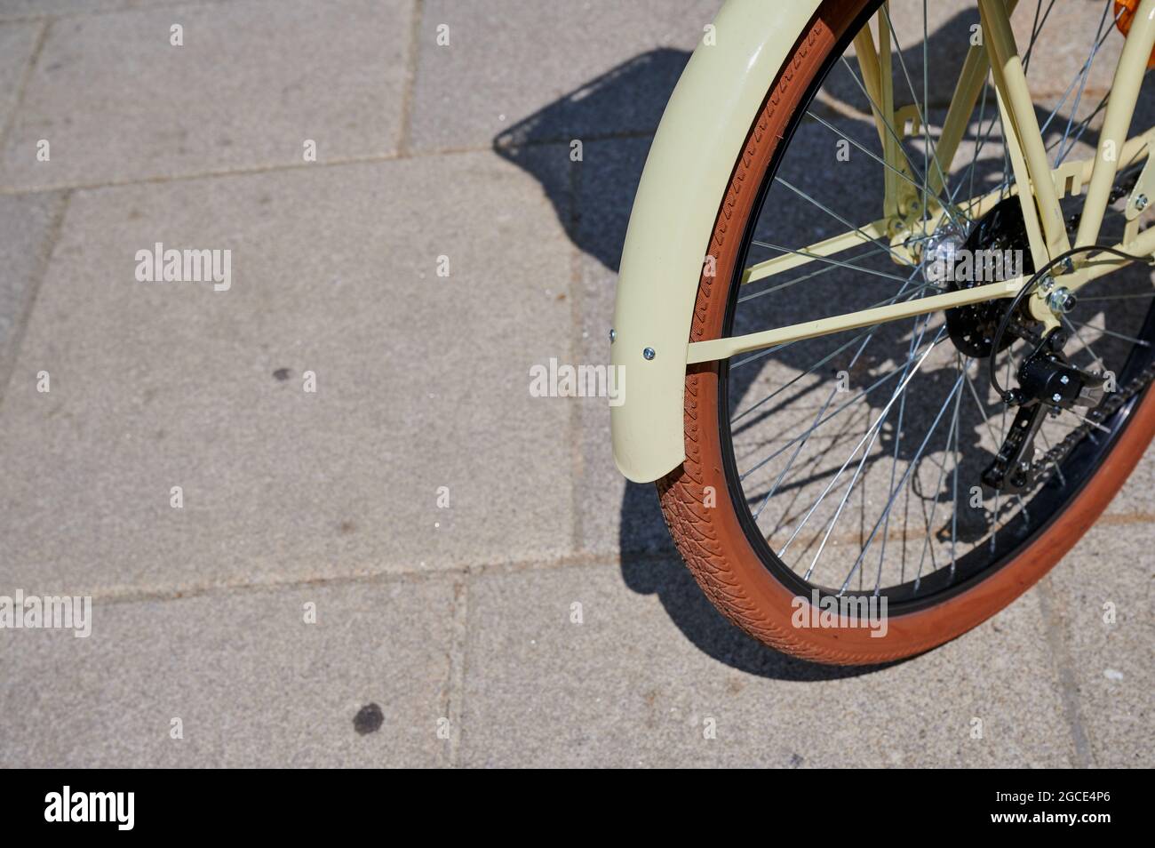 bicycle front wheel in yellow on grey asphalt Stock Photo - Alamy