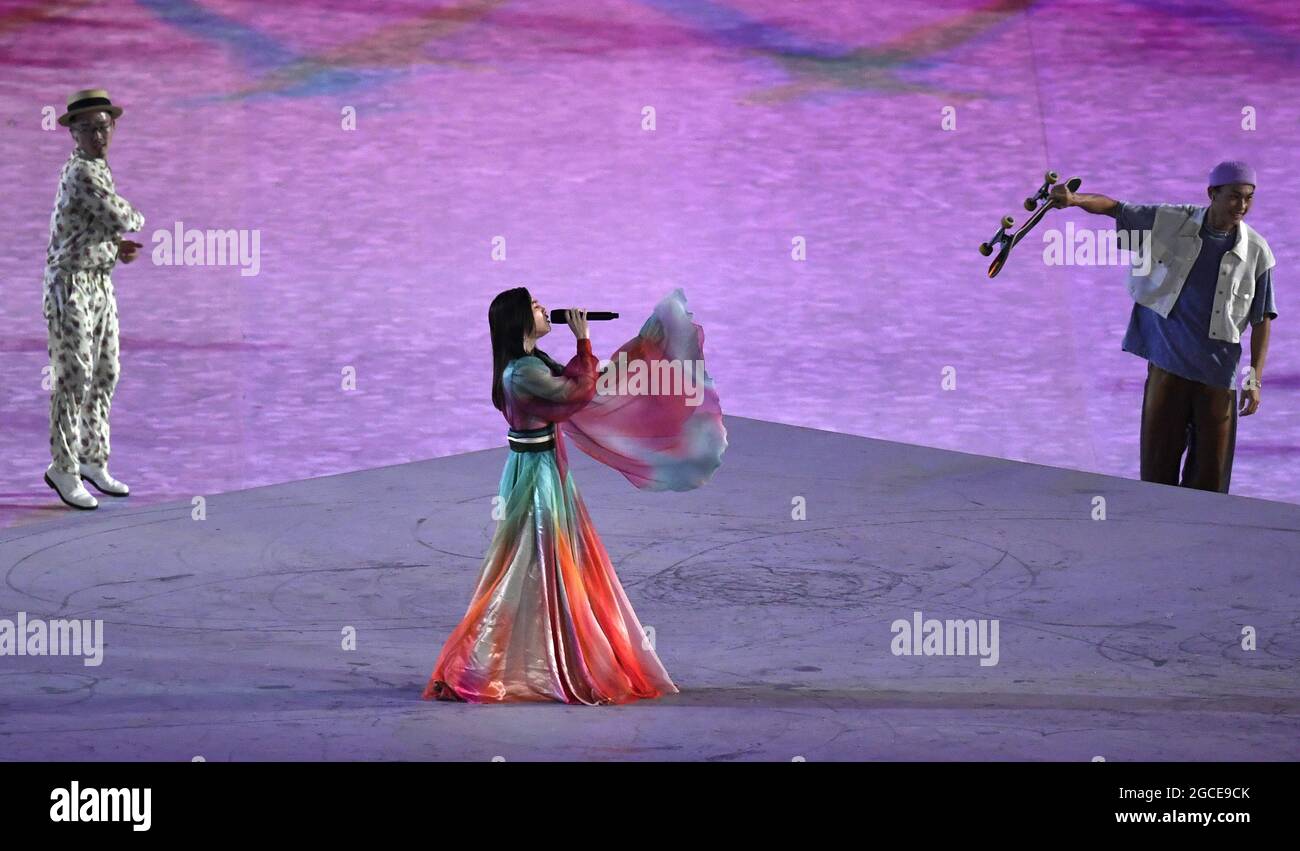 Tokyo, Japan. 08th Aug, 2021. A singer (C) performs as a skateboarder ...