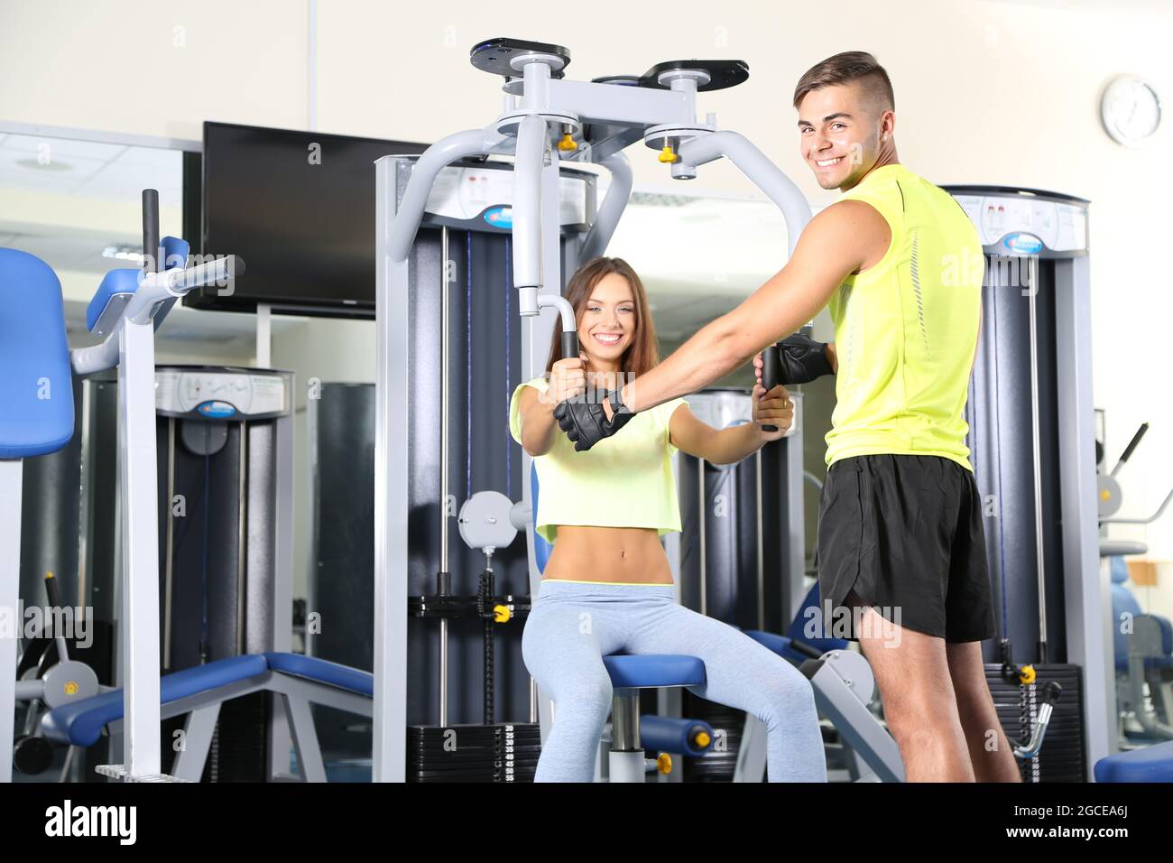 Girl and trainer engaged in simulator in gym Stock Photo - Alamy