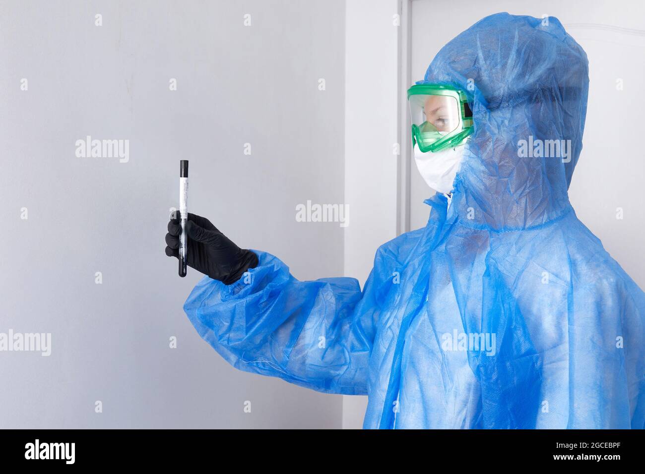 Medical healthcare technologist holding COVID-19 swab, wearing PPE ...