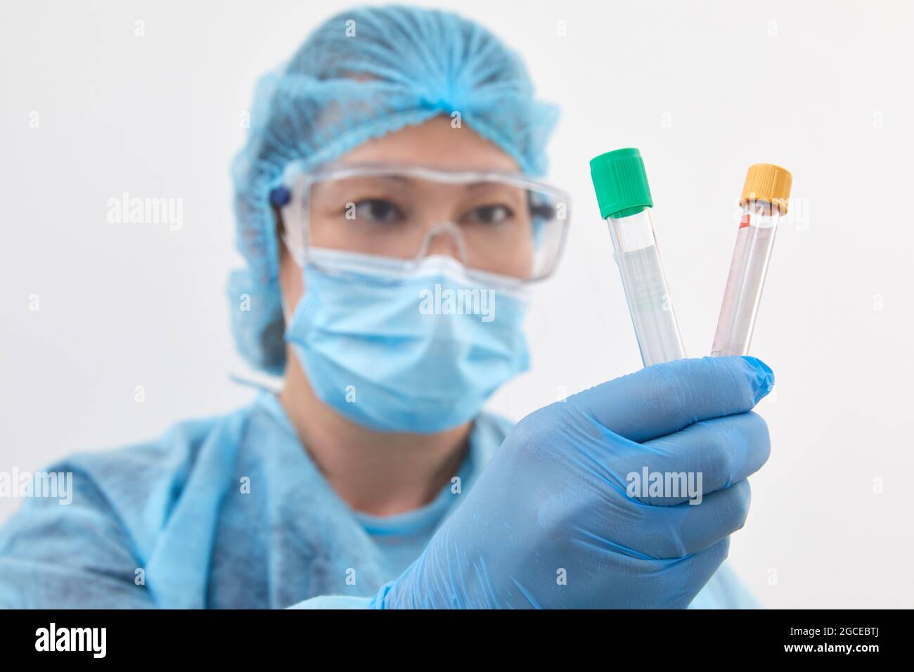 Female scientist holding two test tubes in laboratory doing research ...
