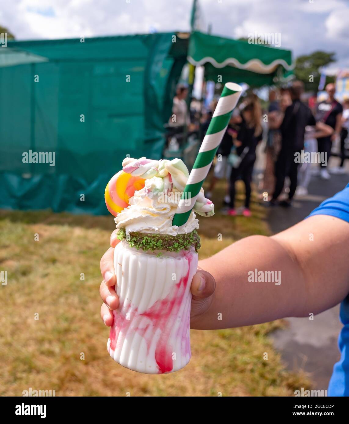Close and selective focus of a human hand holding a specialty milkshake ...