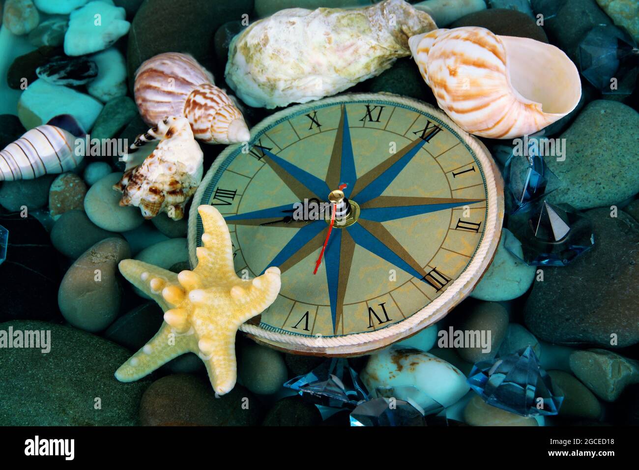 Clock on sea bottom with shells and stones Stock Photo - Alamy