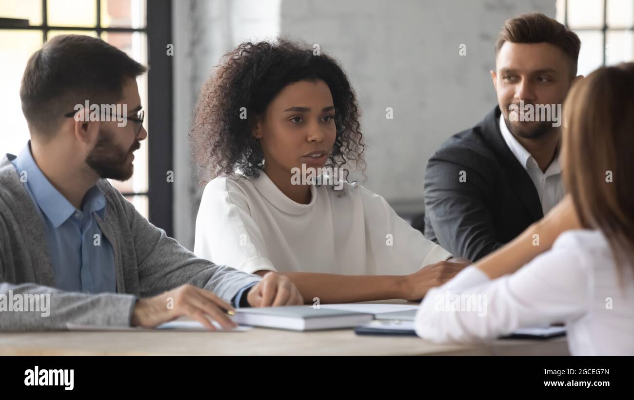 Multiracial employees discuss business idea at team meeting Stock Photo ...
