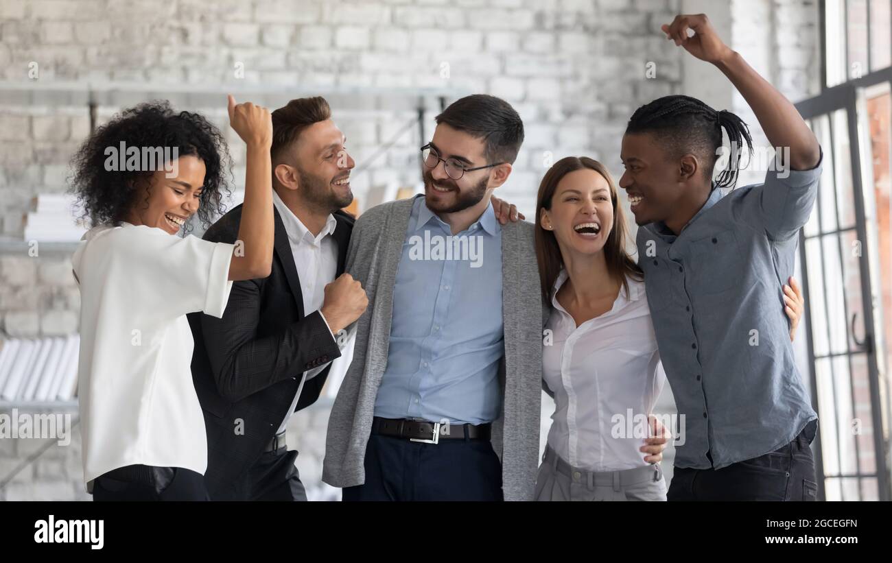 Excited multiethnic businesspeople celebrate shared business success ...