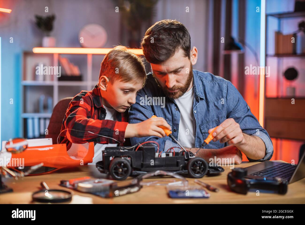 Little boy and young man fixing together remote controlled car with ...