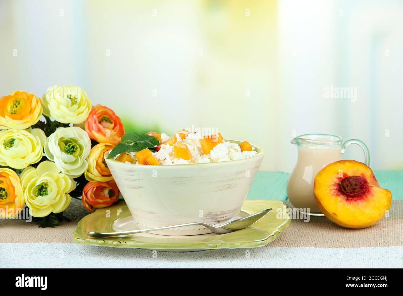 Sour cheese and pieces of fresh peach,on wooden table, on light ...