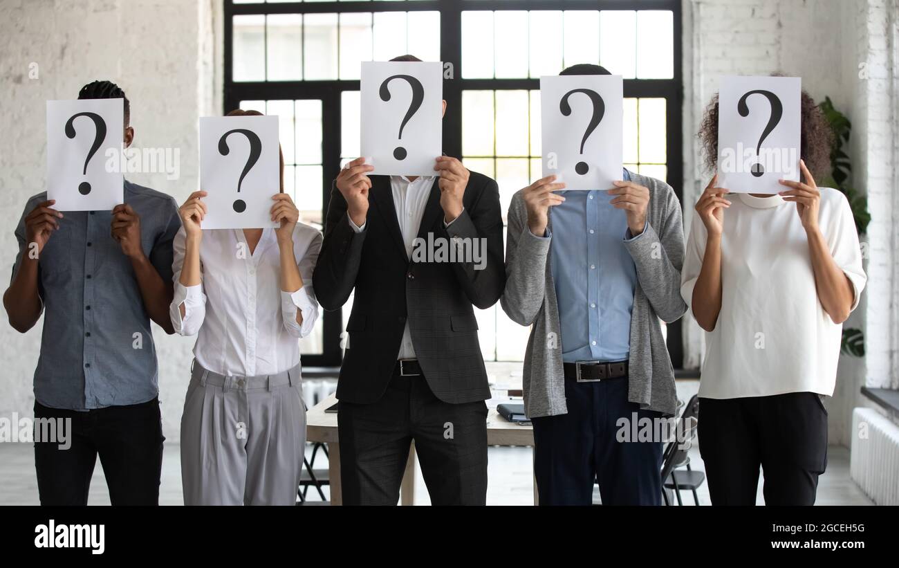 Diverse people hold paper with question mark Stock Photo - Alamy