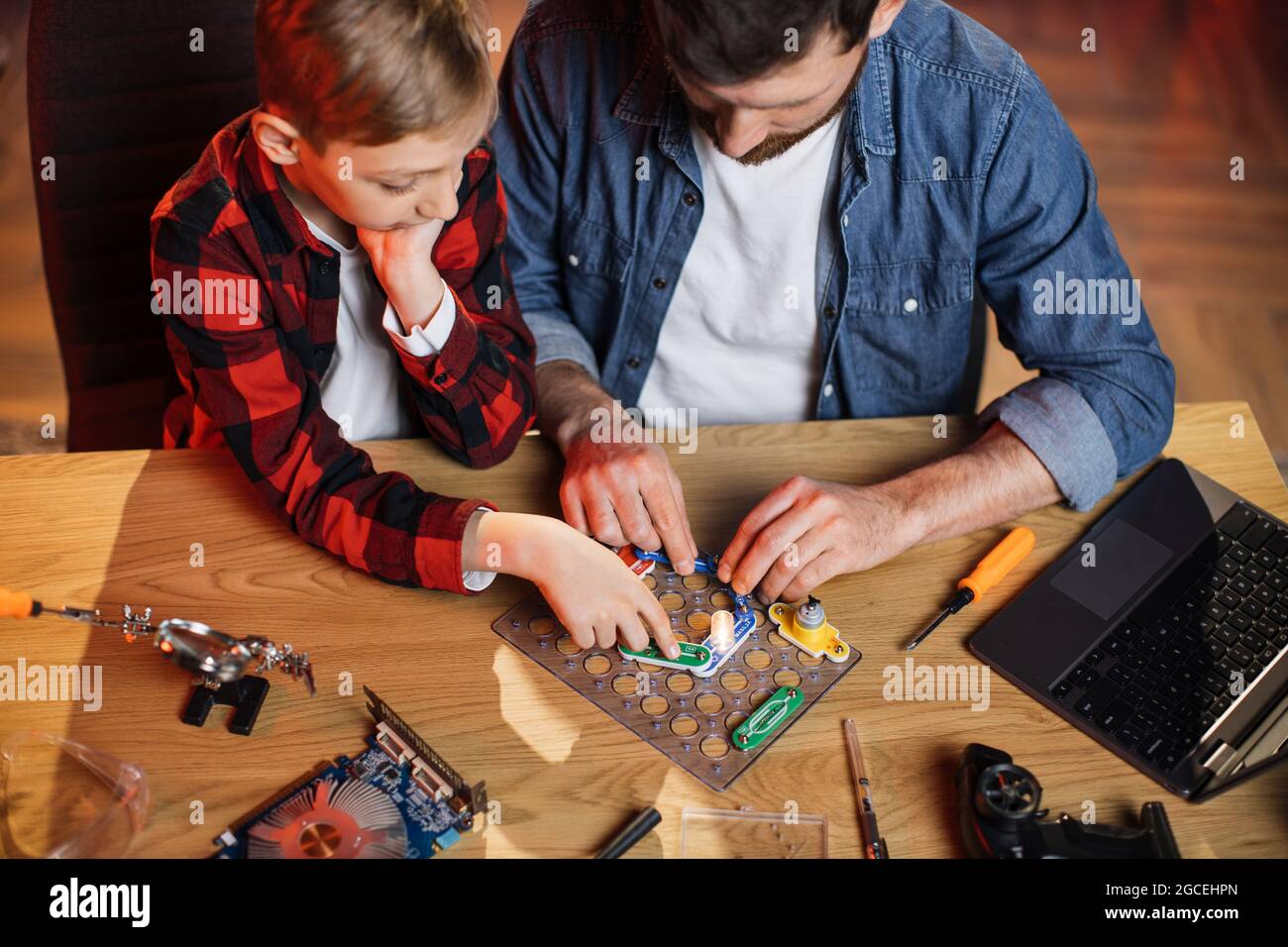 Close up yop view of happy young dad teaching his son physics at home ...