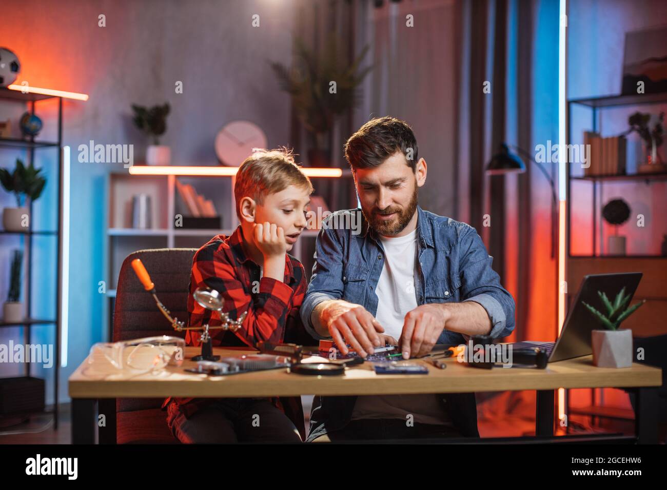 Handsome bearded man and little boy using child designer for physics ...