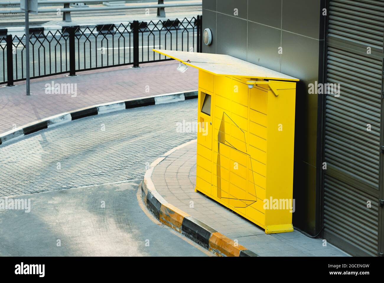 Yellow automatic parcel shipment station at city street. Logistic and e ...