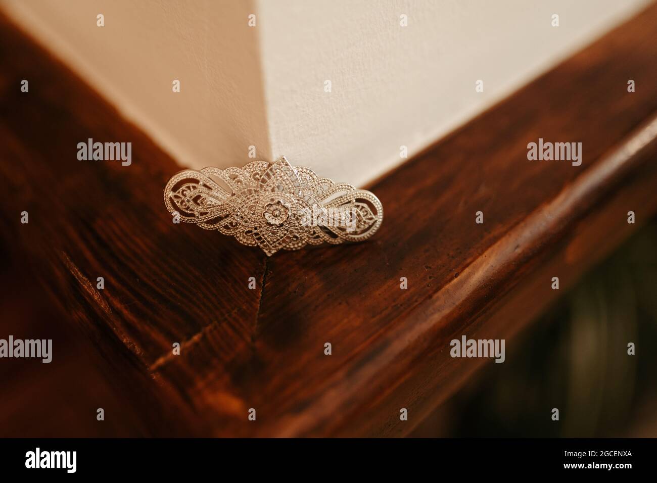 A shiny silver accessory of a bride on a wooden surface Stock Photo - Alamy