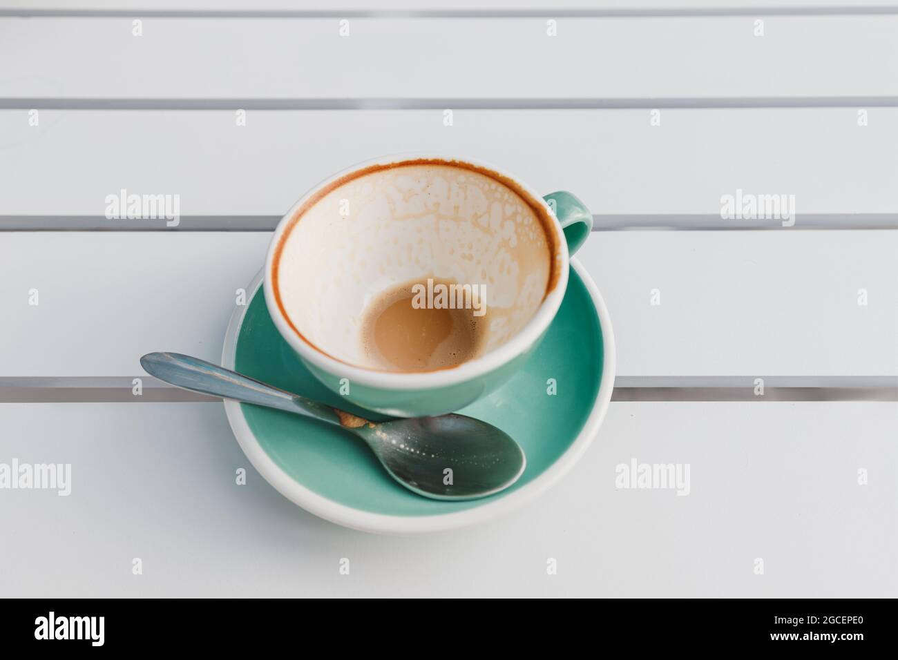 leftover coffee with foam in a mug on the table in the cafe. Drained to ...