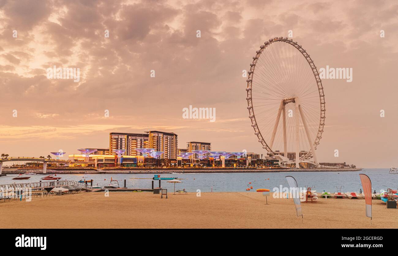 Sandy beach in JBR district and famous Dubai Eye Ferris Wheel during ...
