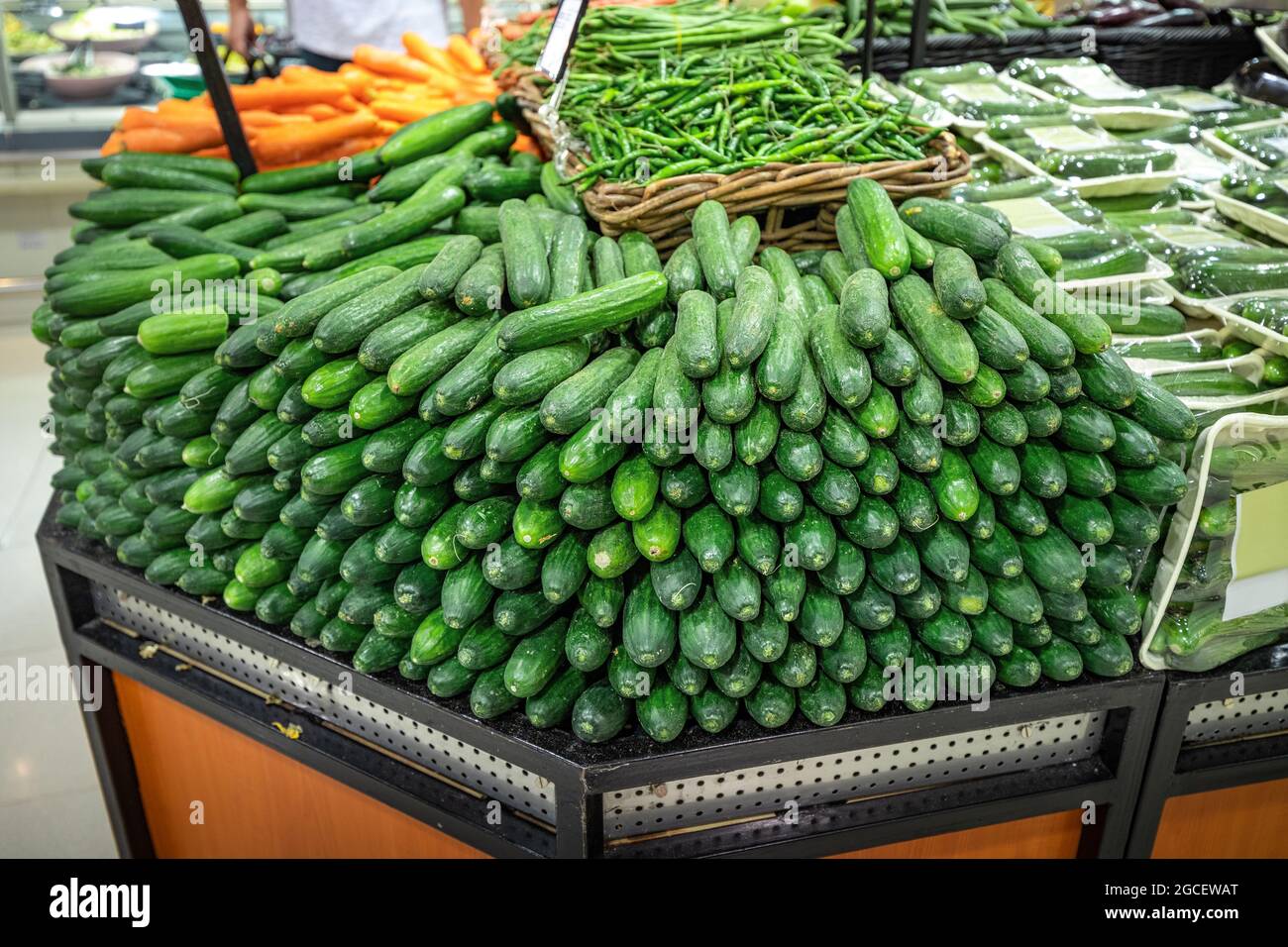 cucumber and other green vegetables on the counter of a grocery store ...