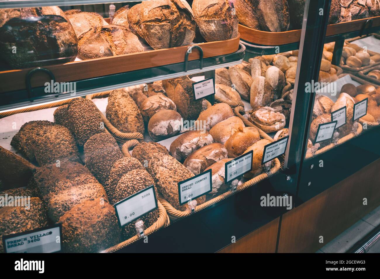 A variety of whole grain loaves of bread in the grocery store window ...