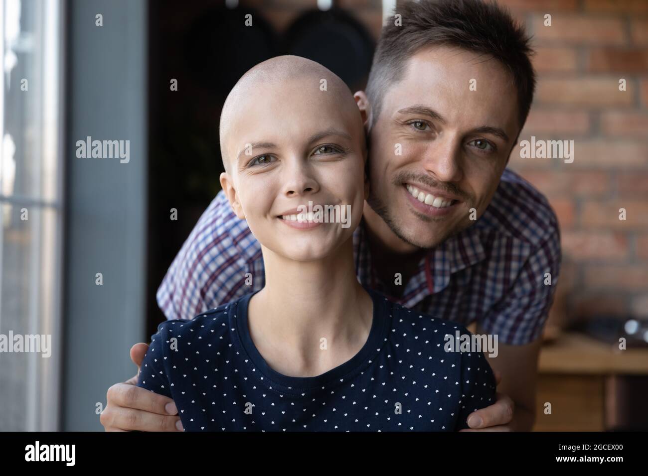 Portrait of happy young man hugging beloved woman with cancer Stock ...