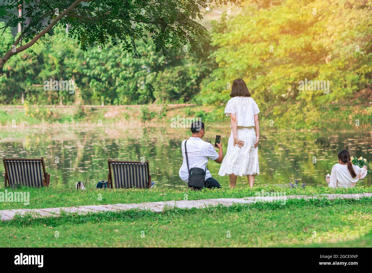 Back view of Asian couples and friend use their phones to take pictures ...
