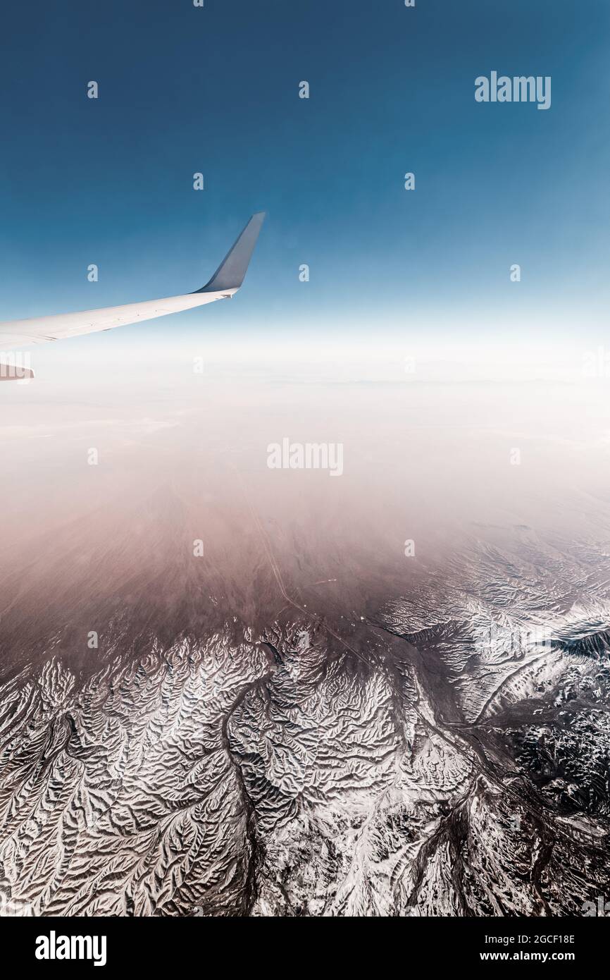 View from the window of an airplane with a wing and a folded terrain ...