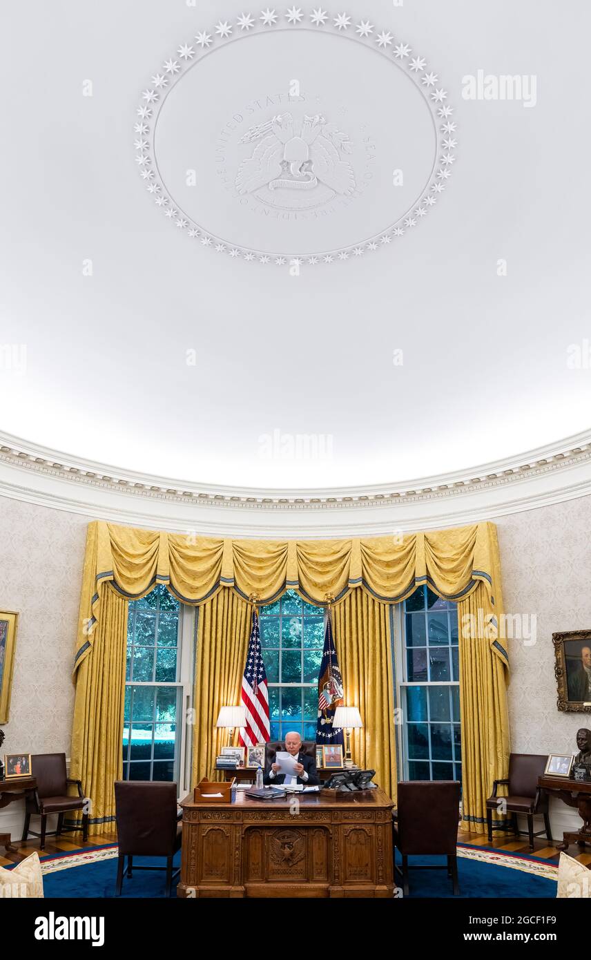 President Joe Biden looks over notes at the Resolute Desk, Wednesday ...