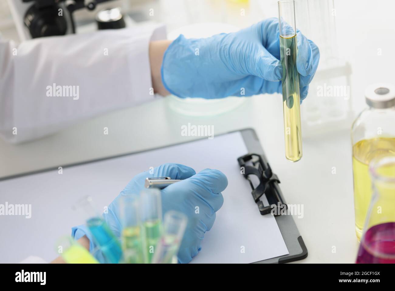 Scientist conducts laboratory tests of transparent liquid in test tube ...