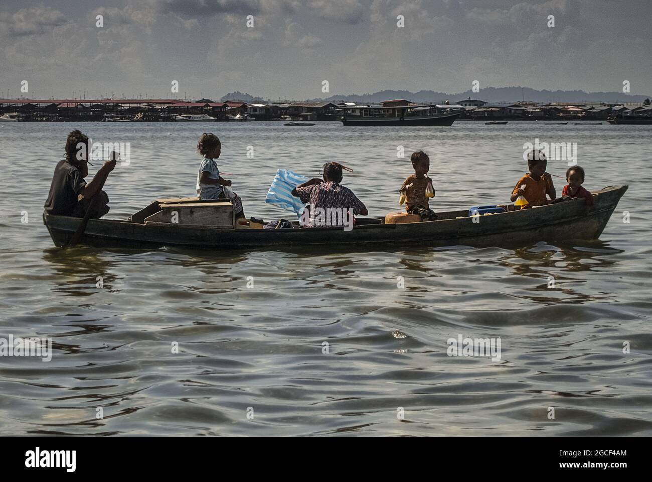 SABAH, MALAYSIA - Feb 19, 2013: A beautiful family on a small wooden ...