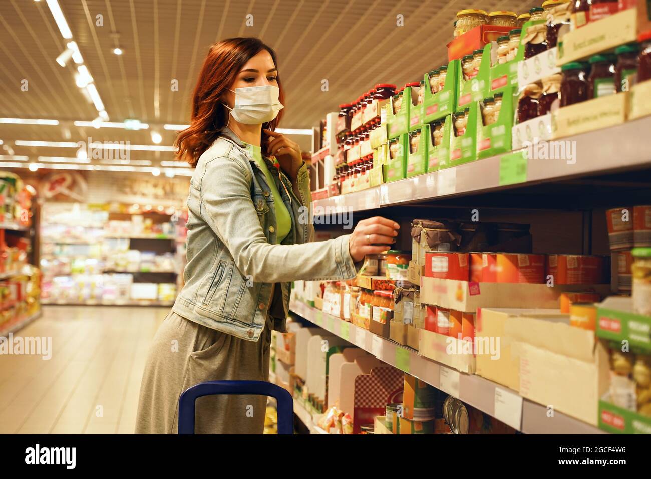 Pretty woman choosing groceries at supermarket. Female consumer ...