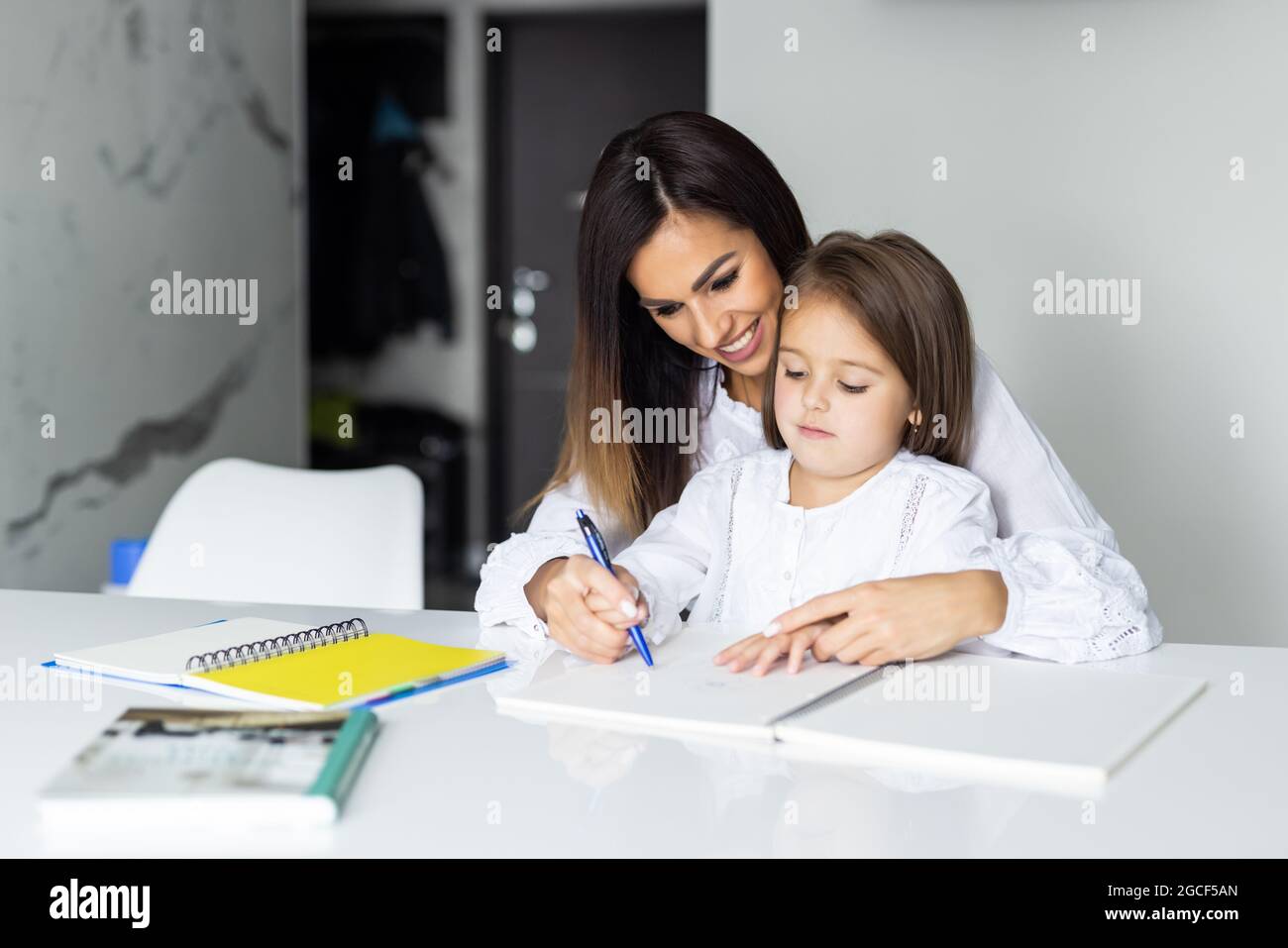 Parent helps the child to do homework. Mother learning her daughter ...