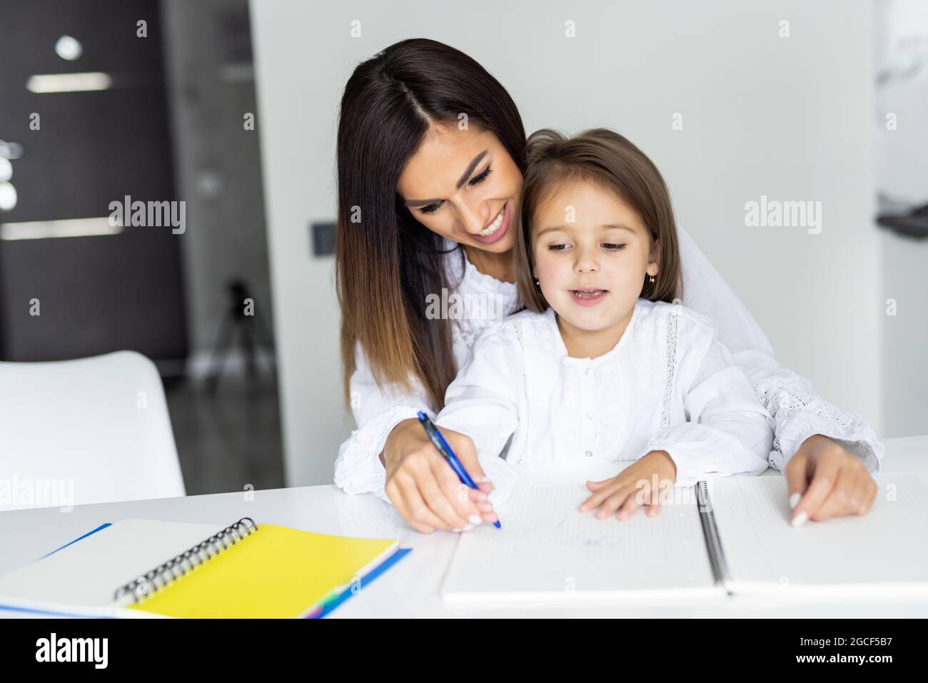 Parent helps the child to do homework. Mother learning her daughter ...