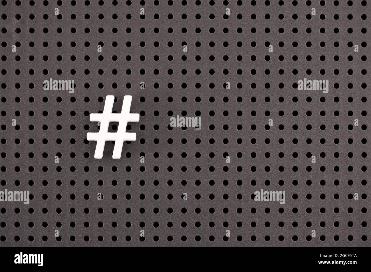 White Hashtag symbol on a gray pegboard Stock Photo - Alamy