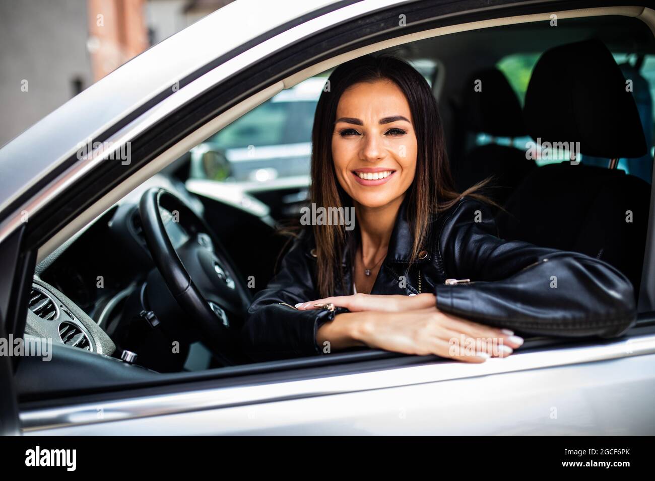 Young woman driving her car in the street Stock Photo - Alamy