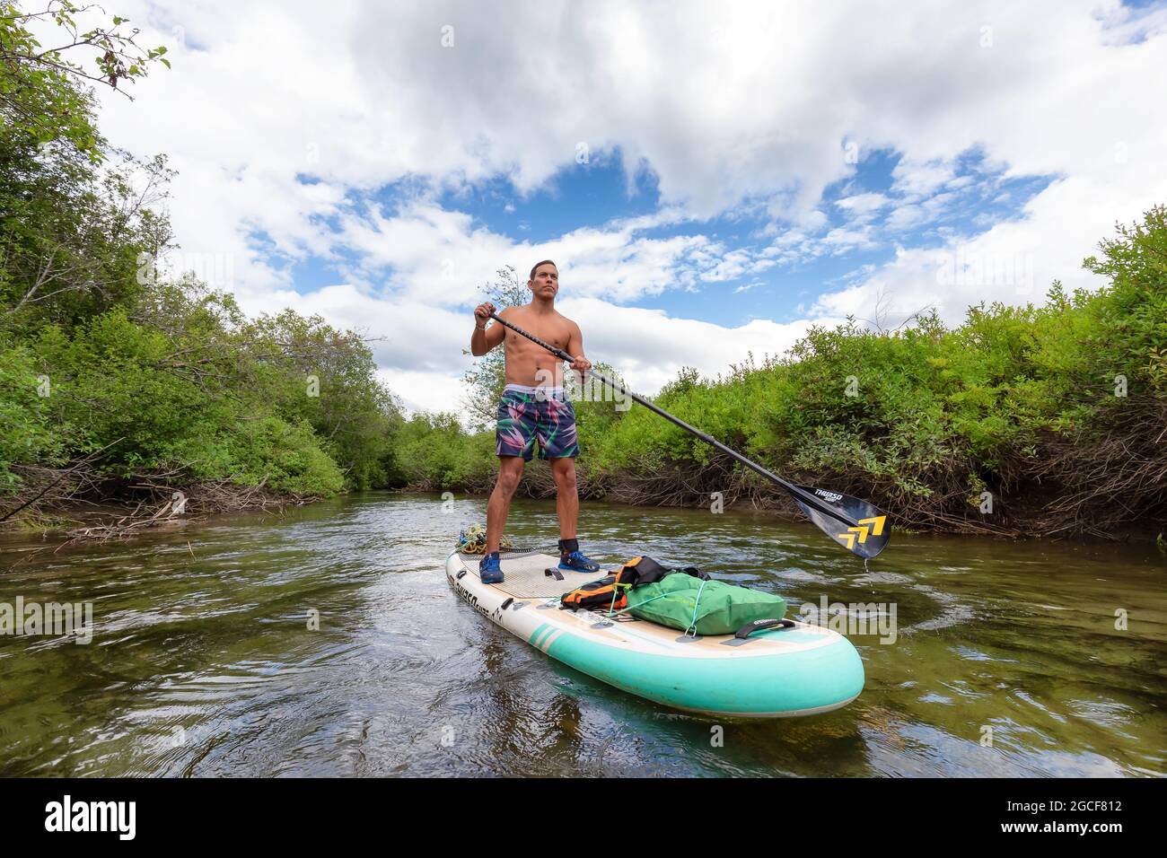 Adventurous people paddle boarding in a river Stock Photo - Alamy