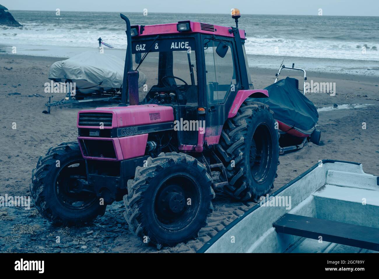 Red tractor on beach towing a boat Stock Photo - Alamy