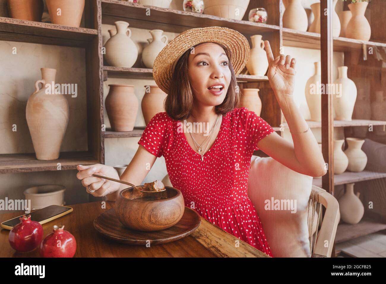 The woman raised her hand and calls the waiter to ask a question about ...