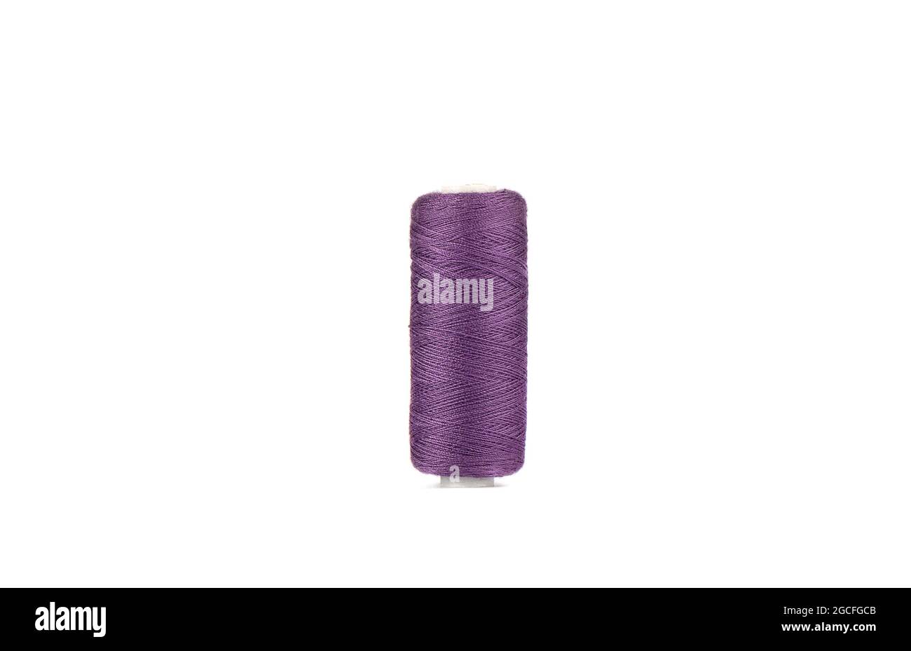 Spool of thread in purple color isolated on white background. Copy ...
