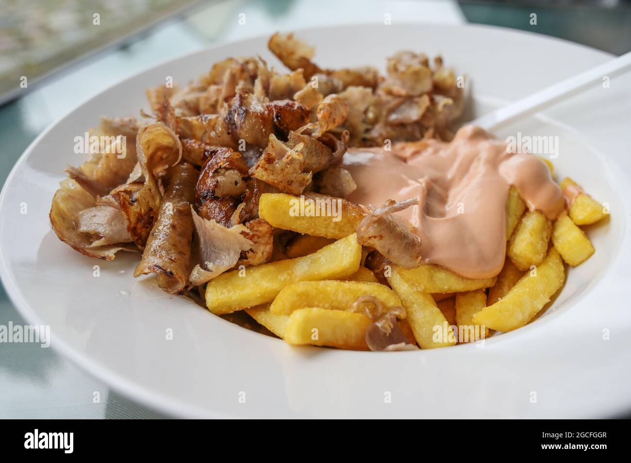 Doner kebab meat from a turkish rotating spit with french fries and ...