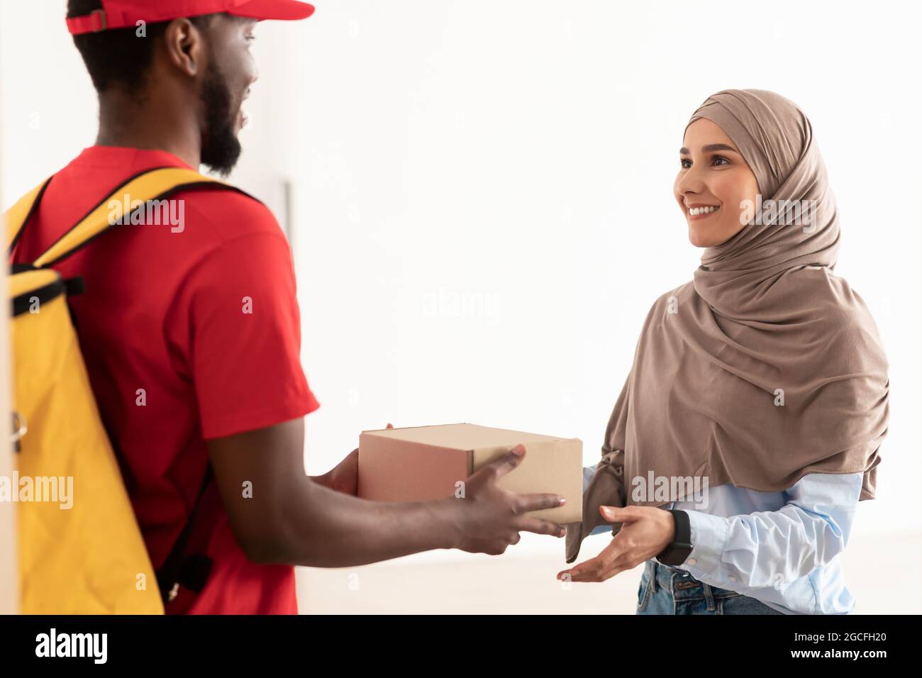 Fast Delivery Concept. Positive female muslim customer in hijab taking ...