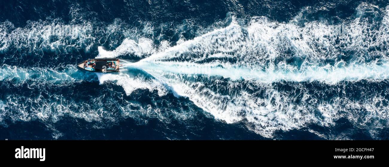 View from above, stunning aerial view of a boat cruising on a blue ...