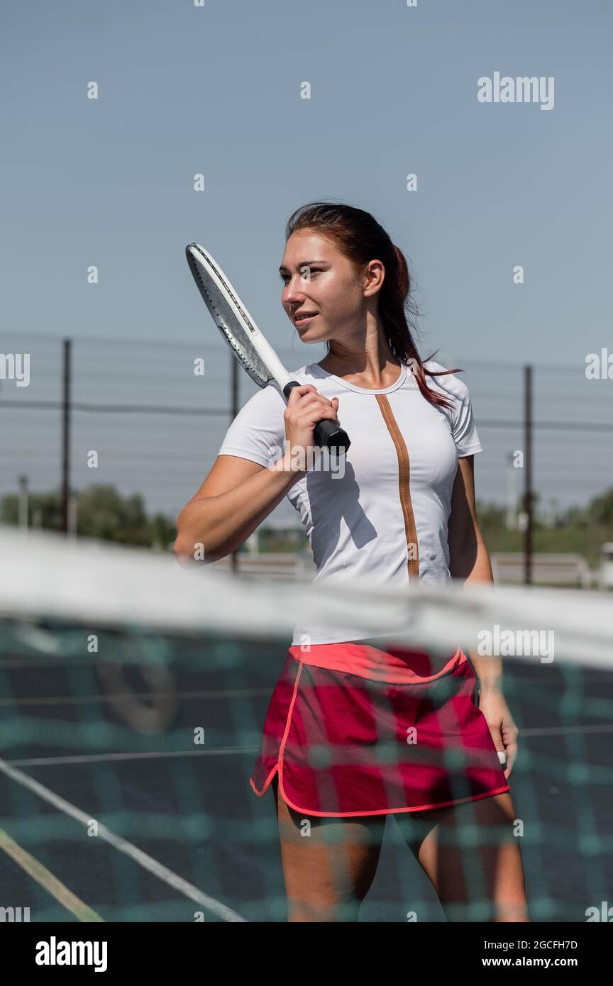 Beautiful smiling woman with a shadow from a tennis racket on her face ...