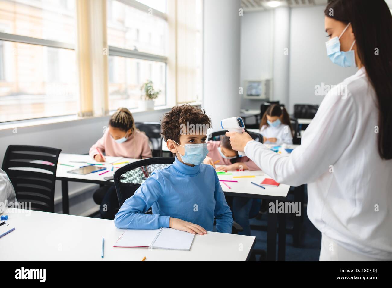 Return To School. Teacher using digital medical contactless infrared ...