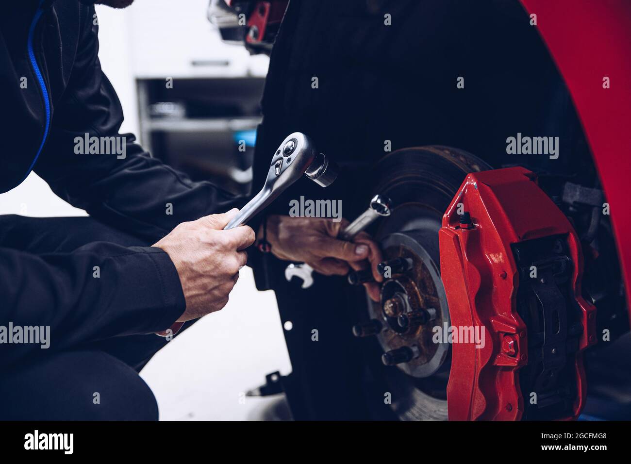 Car mechanic repairing car brakes in car service Stock Photo - Alamy