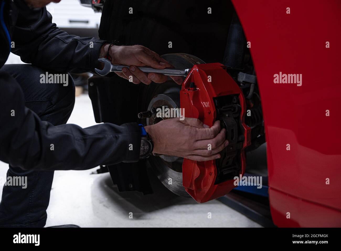 Car mechanic repairing car brakes in car service Stock Photo - Alamy