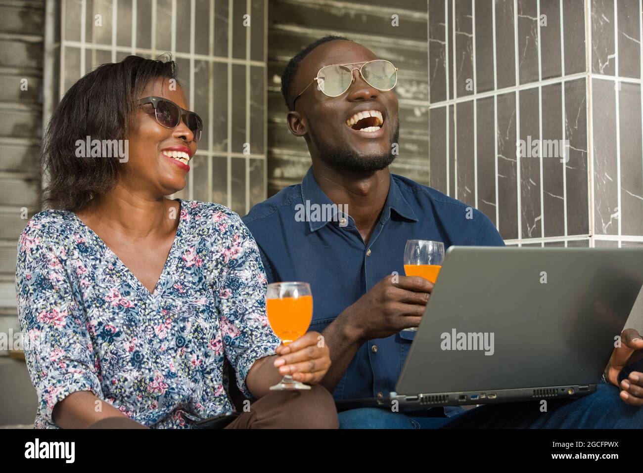 handsome man with laptop and smiling girl with shopping bag sitting ...