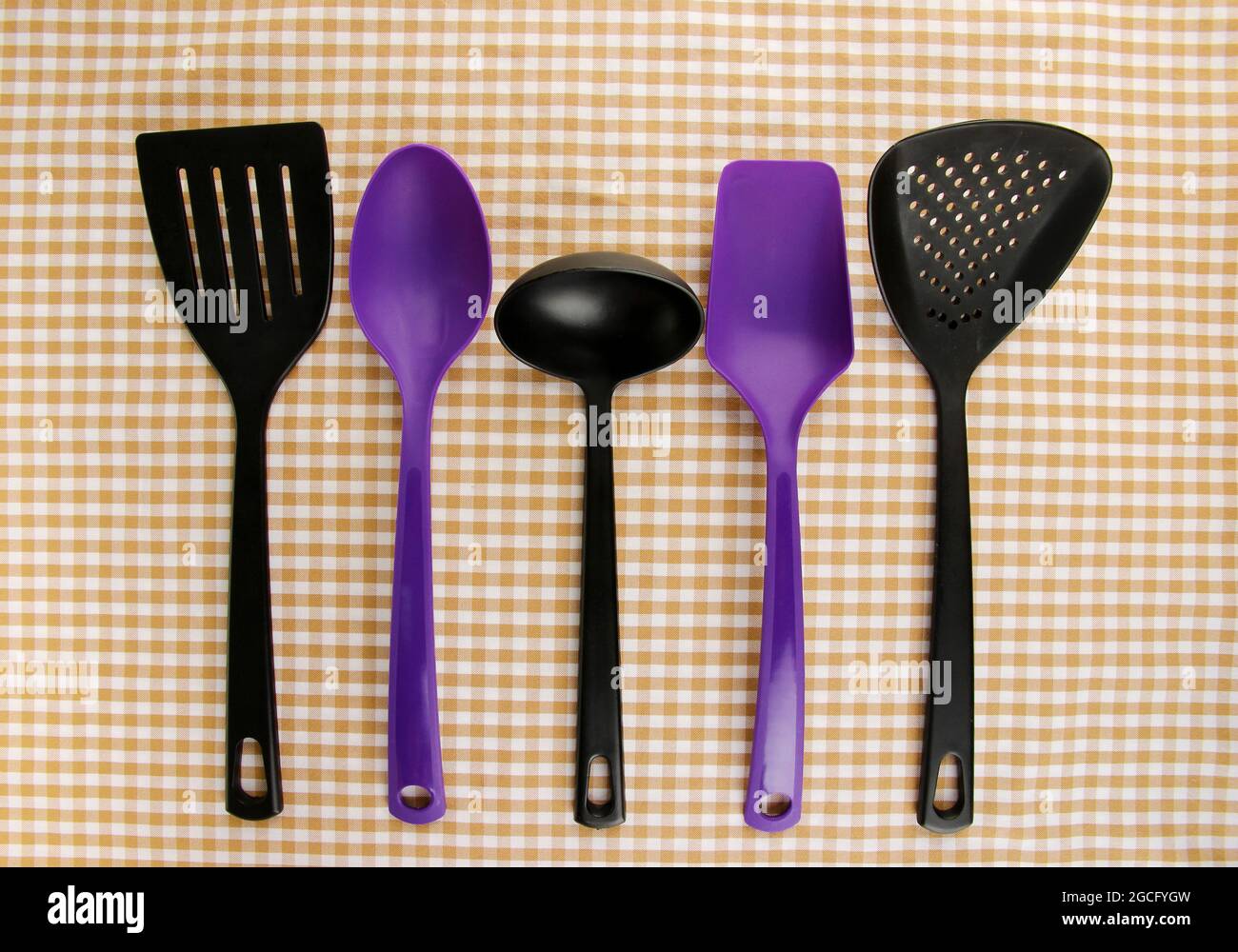 Plastic kitchen utensils on fabric background Stock Photo - Alamy