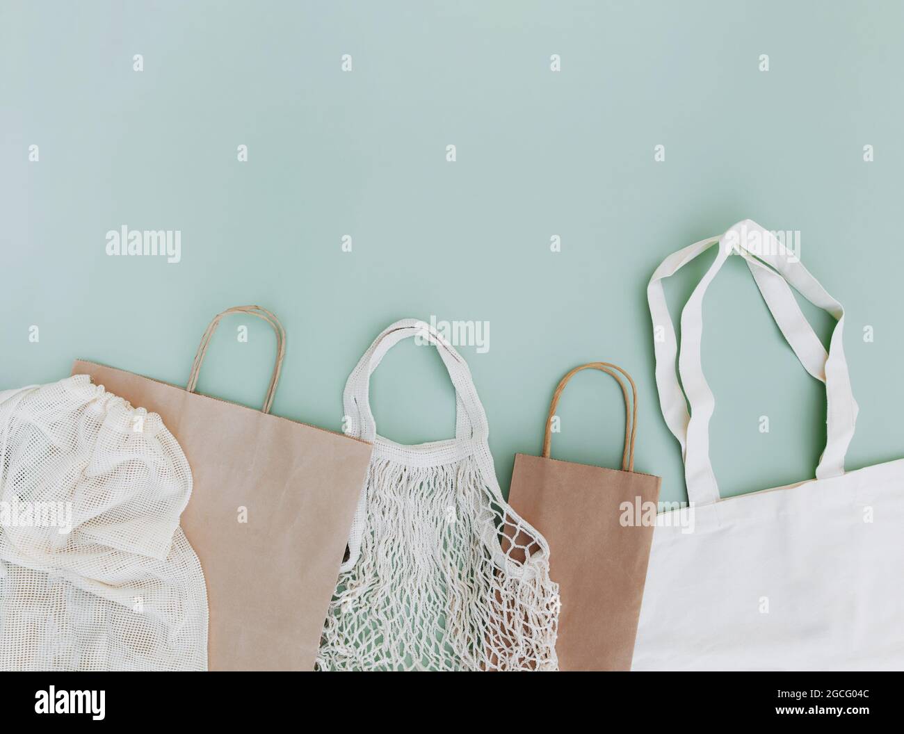 Flat lay with eco white craft paper bags and net bags on green ...