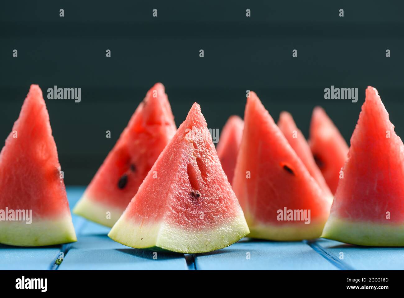 Bright organic watermelon cut into triangles on blue background with copyspace Stock Photo - Alamy