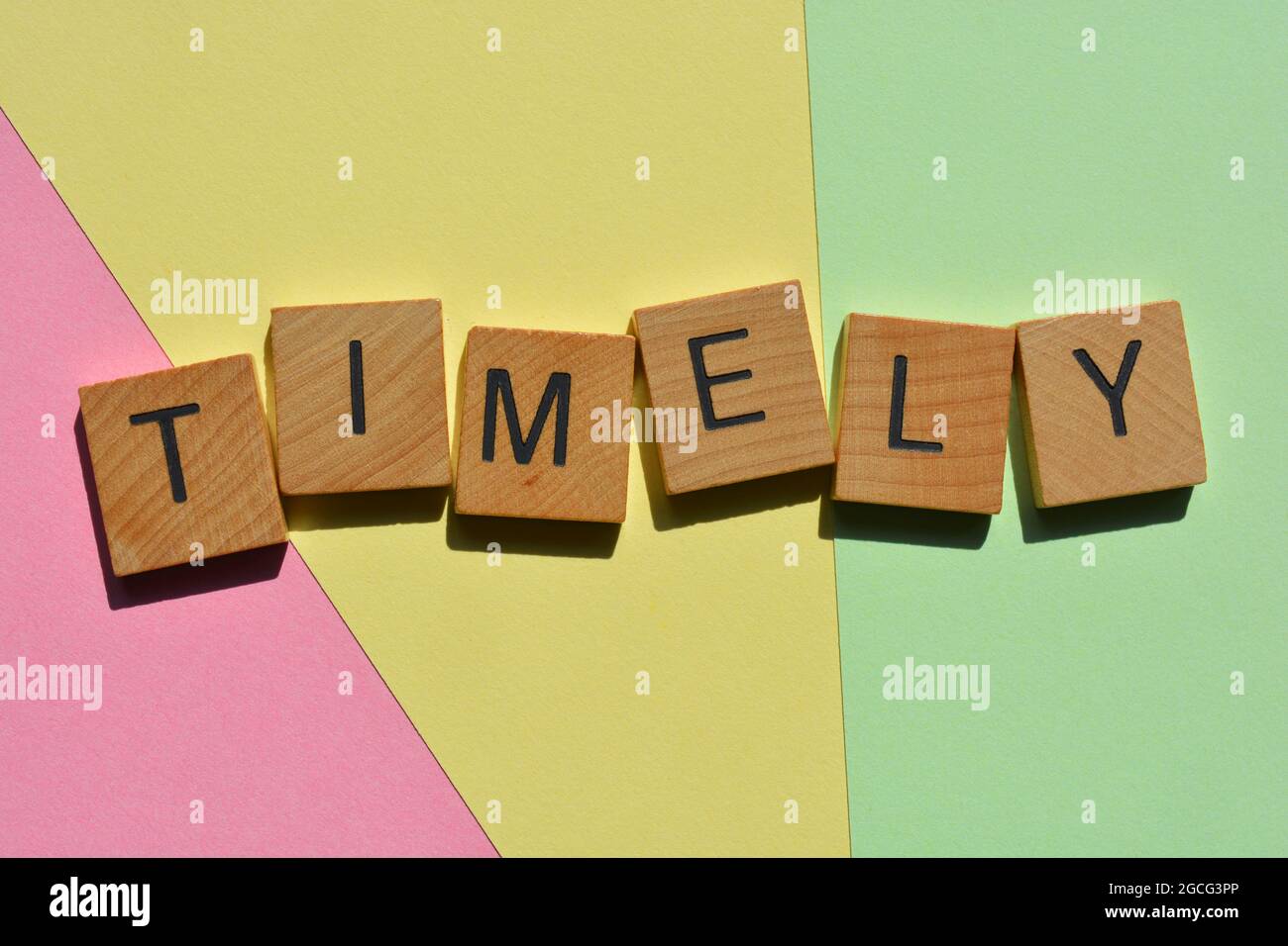 Timely, word in wooden alphabet letters isolated on colourful ...