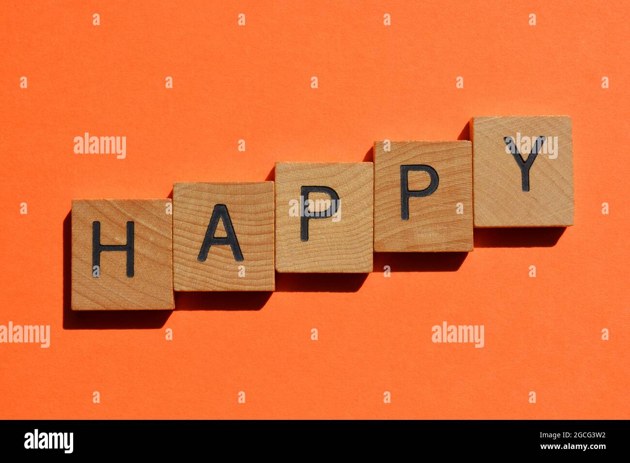 Happy, word in wooden alphabet letters isolated on bright orange ...
